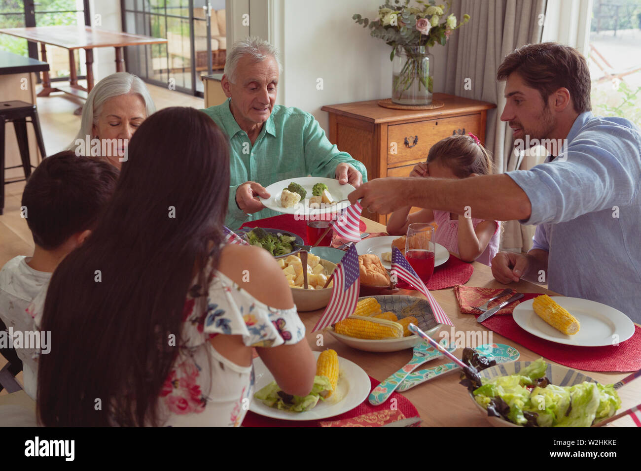 Multi-generation family having food on dining table at home Stock Photo ...
