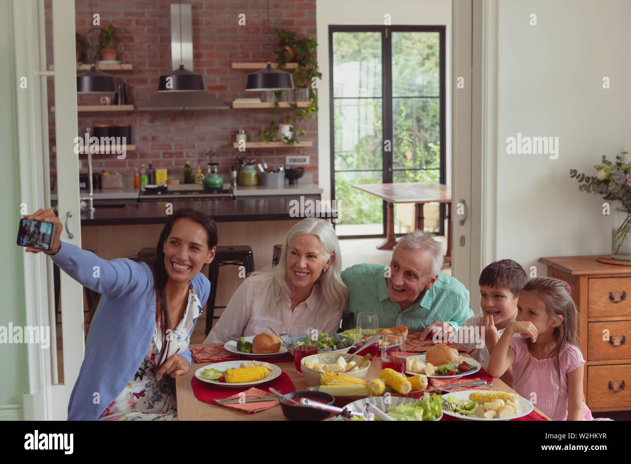 Multi-generation family taking selfie with mobile phone while having ...