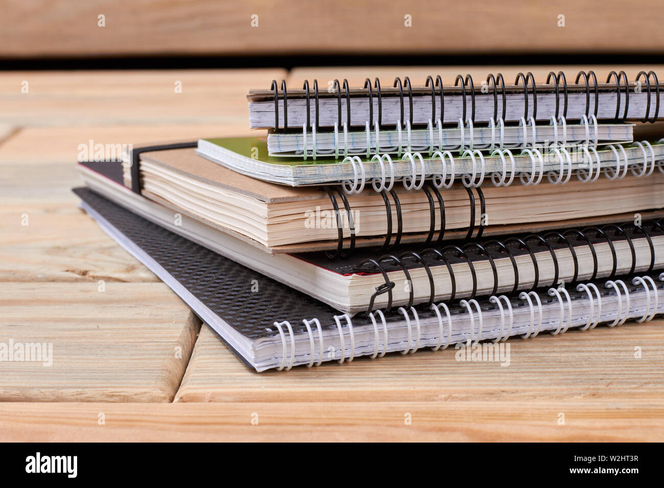 Stack of spiral notebooks on wooden background Stock Photo - Alamy