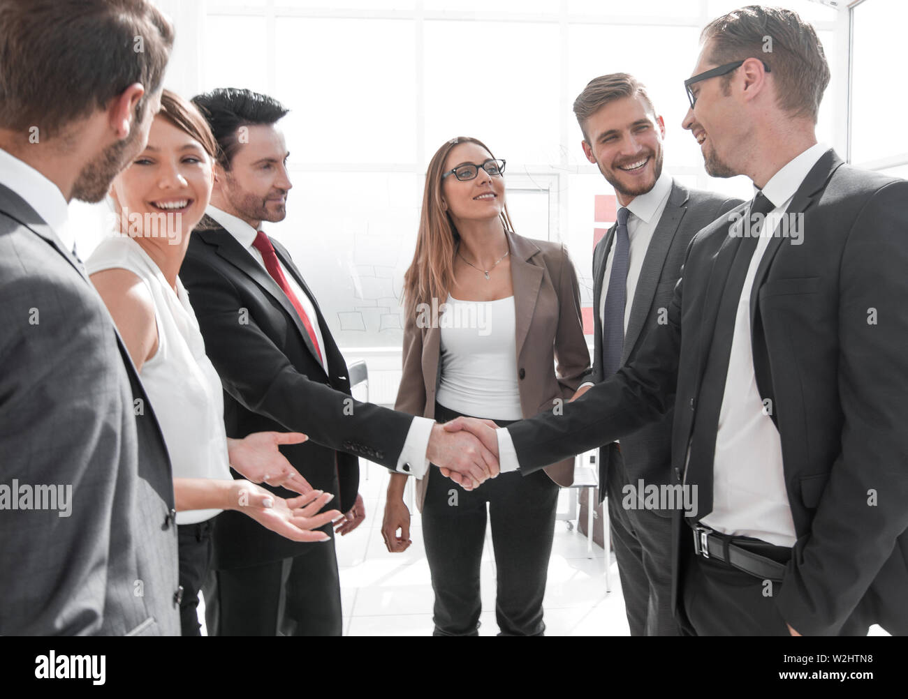 Business handshake in a modern office Stock Photo - Alamy