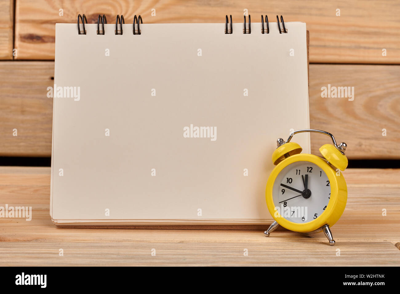 Blank binder notebook and alarm clock Stock Photo - Alamy