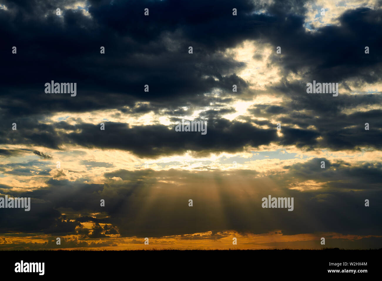 Beautiful sunset - dark sky with clouds and sunlight Stock Photo - Alamy