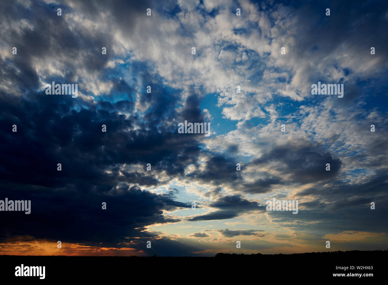 Beautiful sunset - dark sky with clouds and sunlight Stock Photo - Alamy