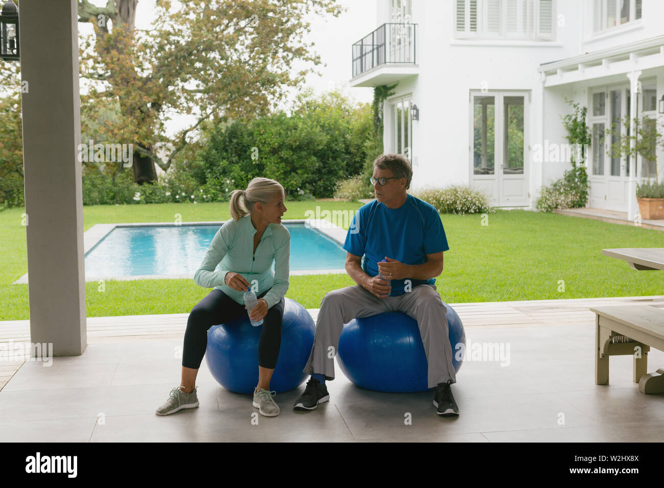 Active senior couple talking with each other after workout in the porch ...