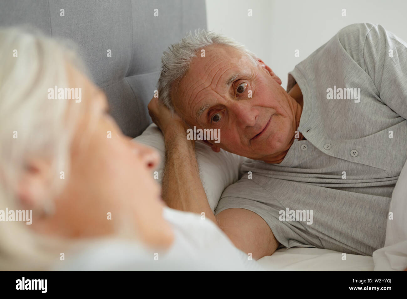 Senior man talking with senior woman while sleeping in bedroom Stock ...