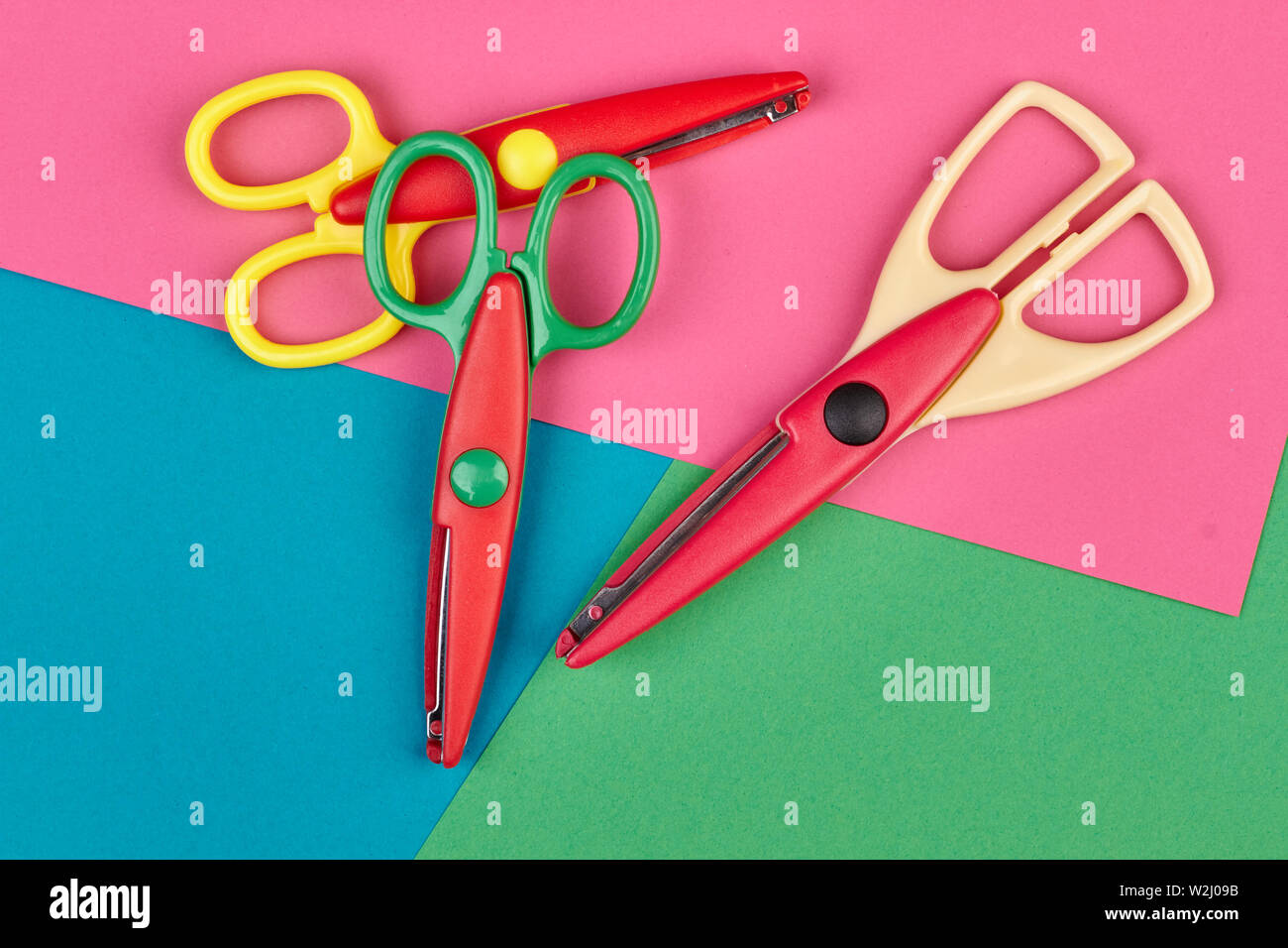 Three colorful scissors on color paper background Stock Photo - Alamy