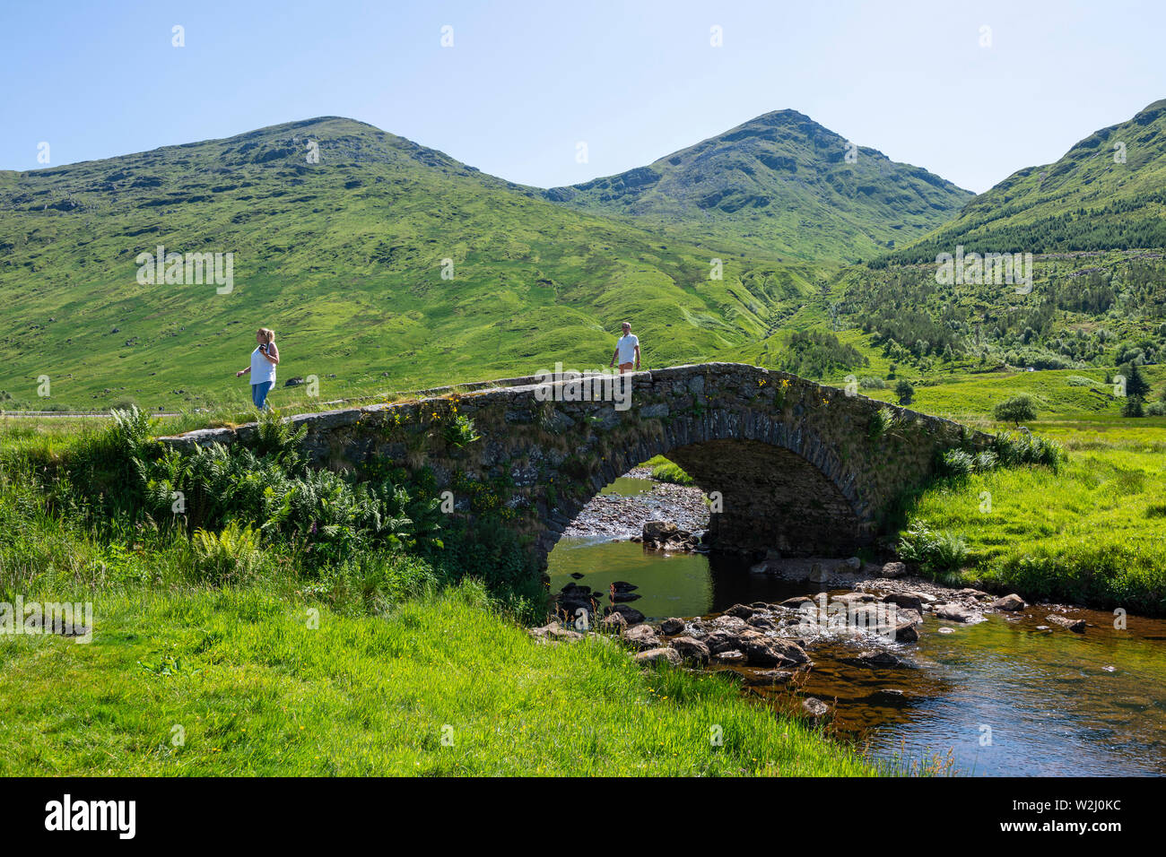 Tourists crossing Butterbridge, an old stone single arched bridge, over ...