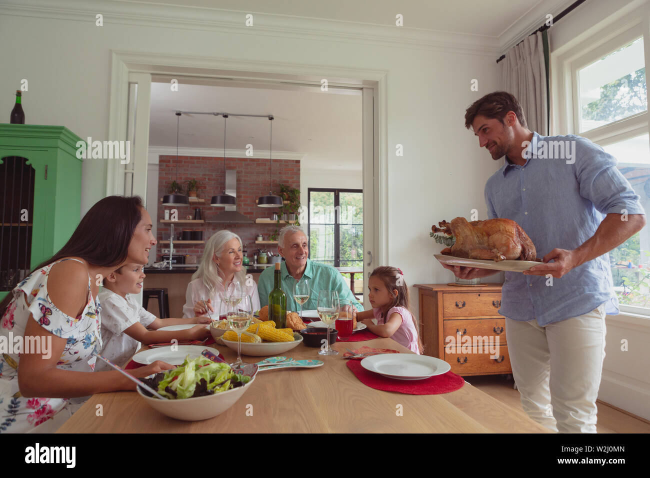 Multi-generation family having food on dining table at home Stock Photo ...