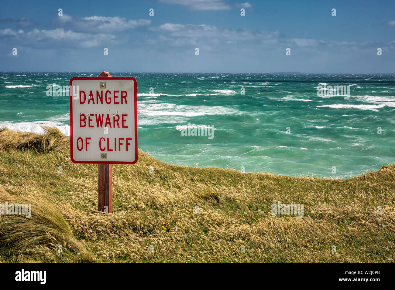 Danger sign at coast with huge waves near Bluff, New Zealand Stock ...