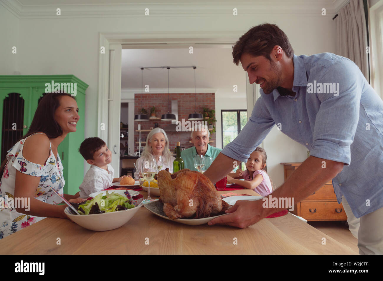 Multi-generation family having food on dining table at home Stock Photo ...