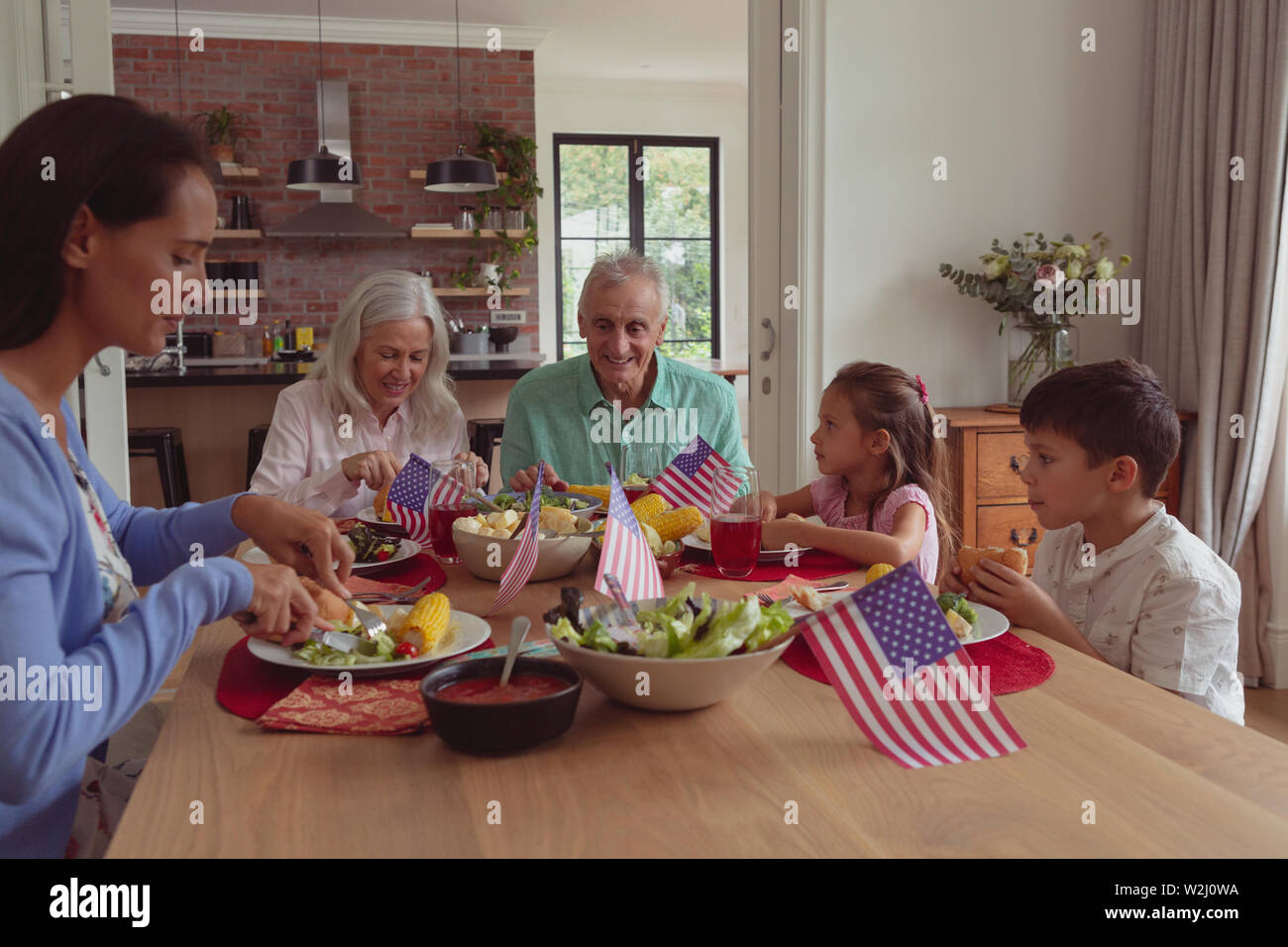 Multi-generation family having food on dining table at home Stock Photo ...