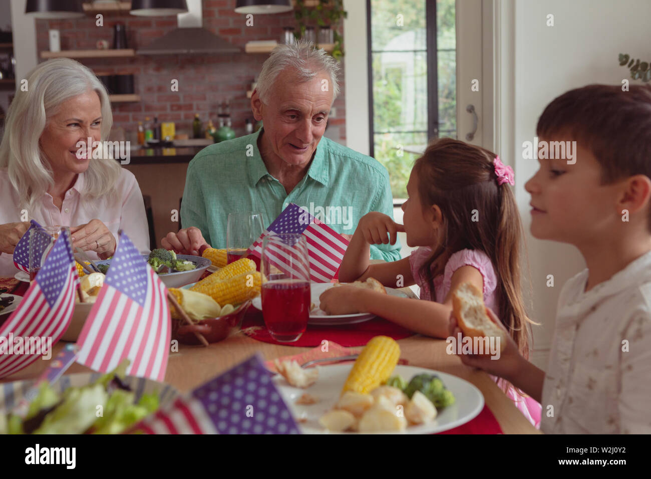 Multi-generation family having food on dining table at home Stock Photo ...