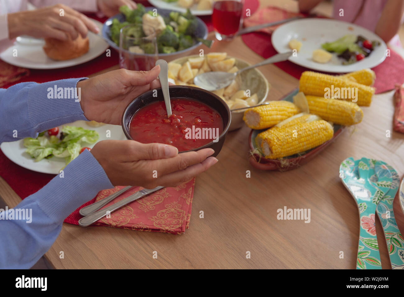 Multi-generation family having food on dining table at home Stock Photo ...