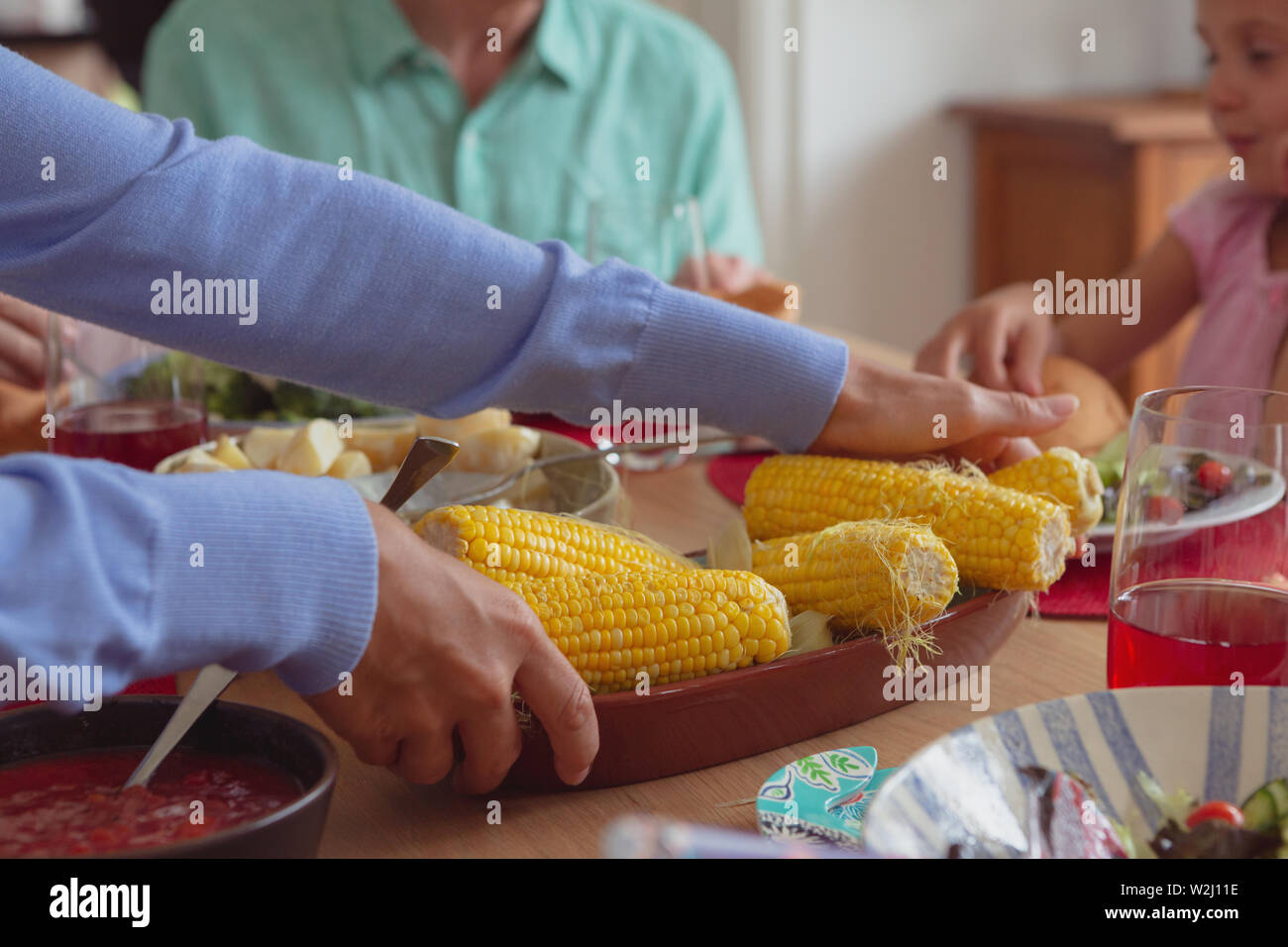 Multi-generation family having food on dining table at home Stock Photo ...