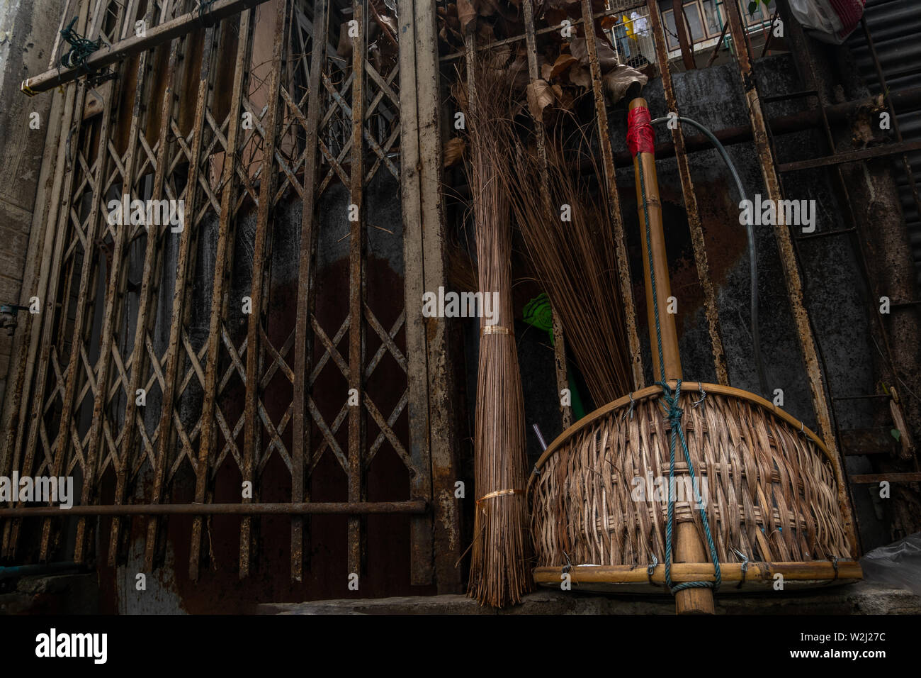 Old broomstick and collects garbage in scoop on the road, near to the ...