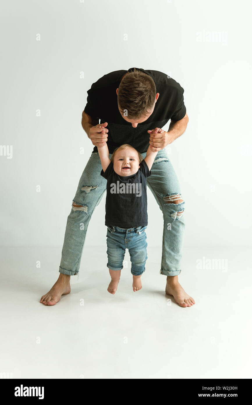 Happy father holding adorable little son and smiling at camera. Young ...