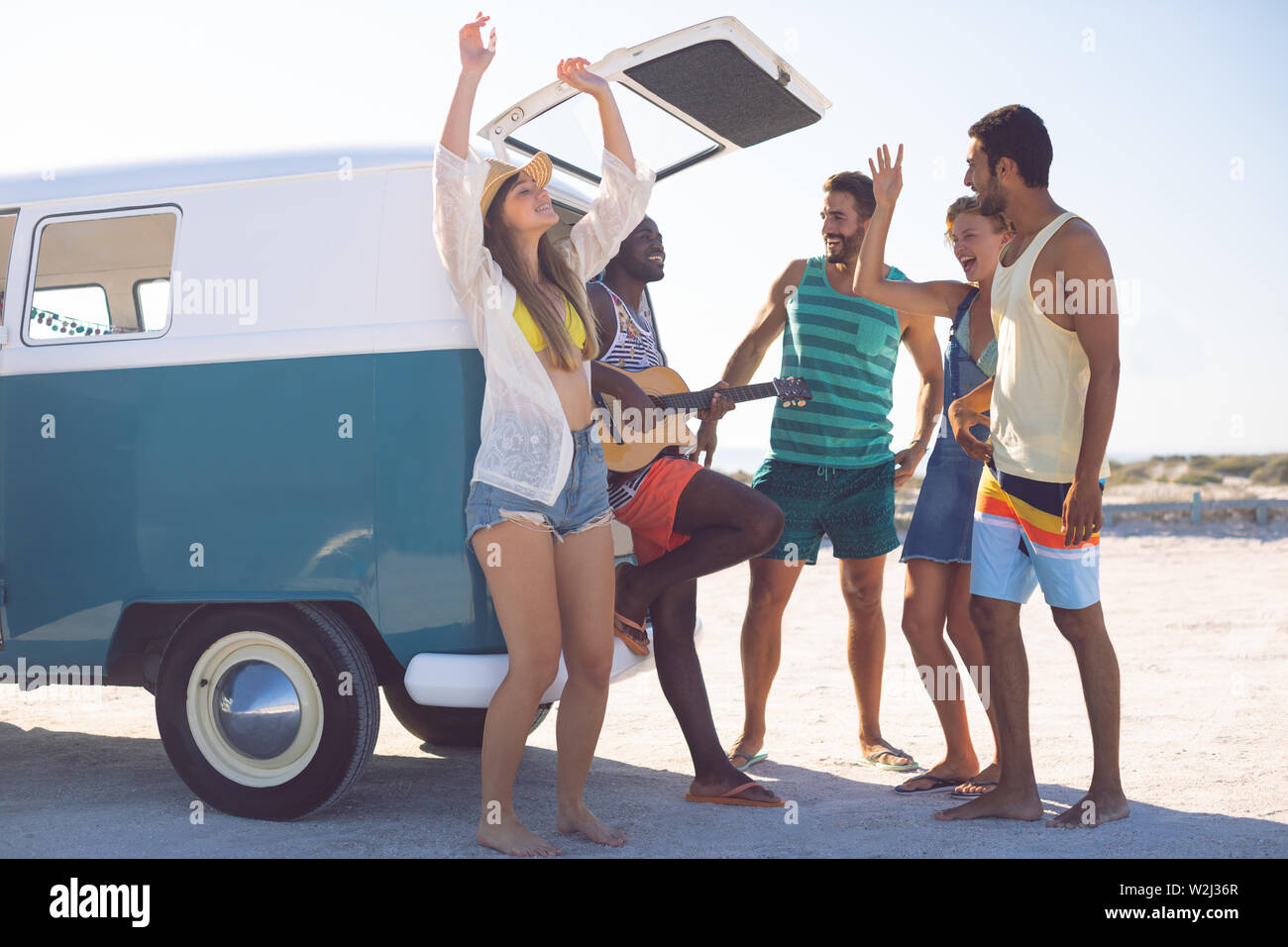 Group of friends having fun together near camper van at beach Stock ...