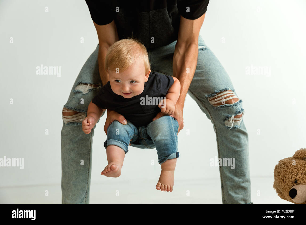 Happy father holding adorable little son and smiling at camera. Young ...