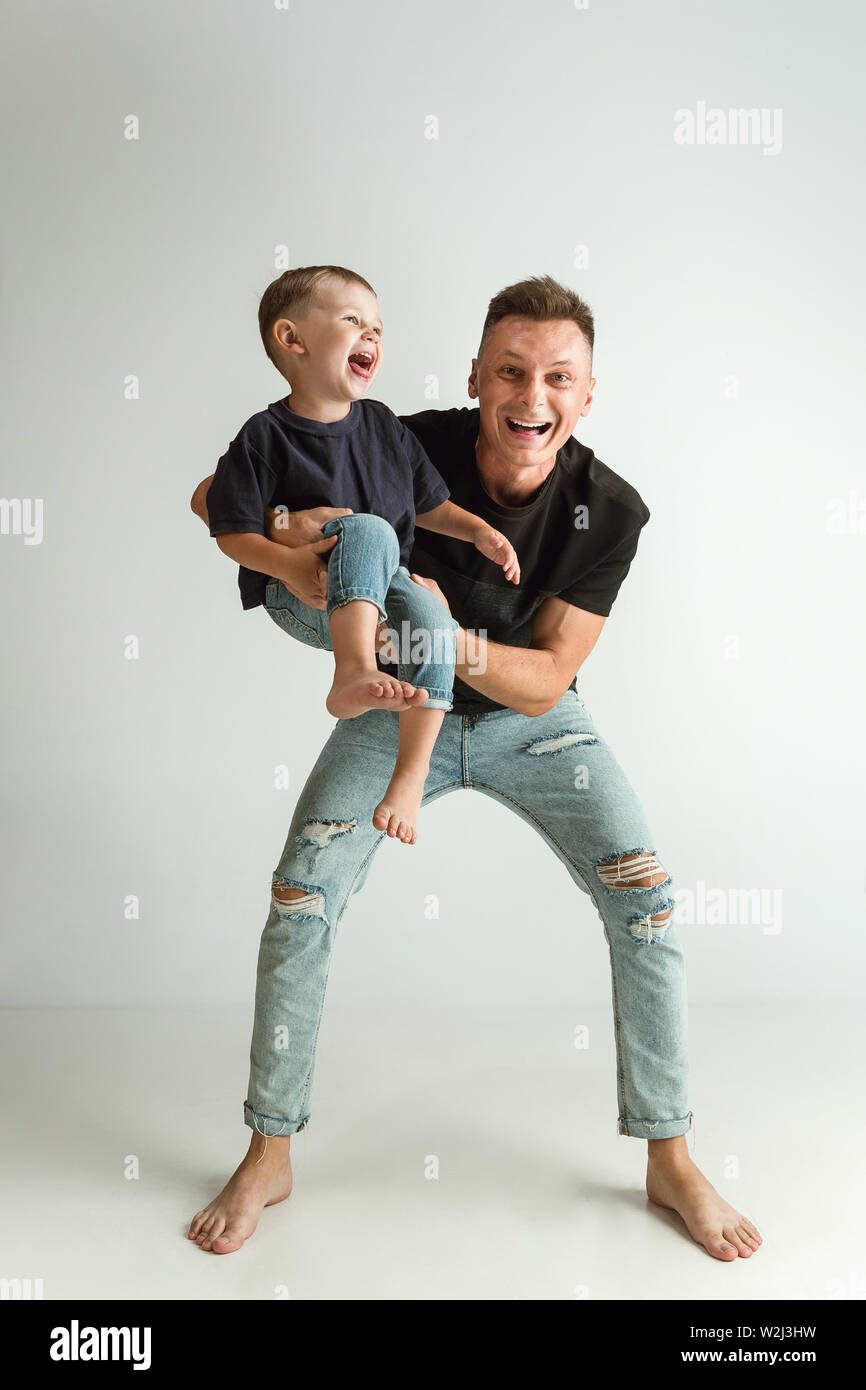 Happy father holding adorable little son and smiling at camera. Young ...