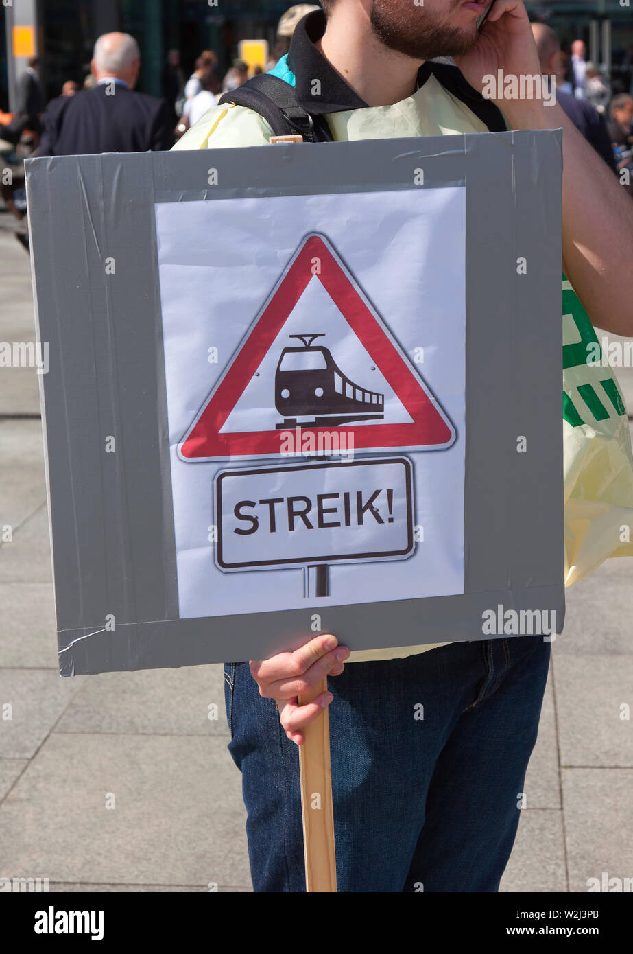 Protester holding a sign saying strike Stock Photo - Alamy