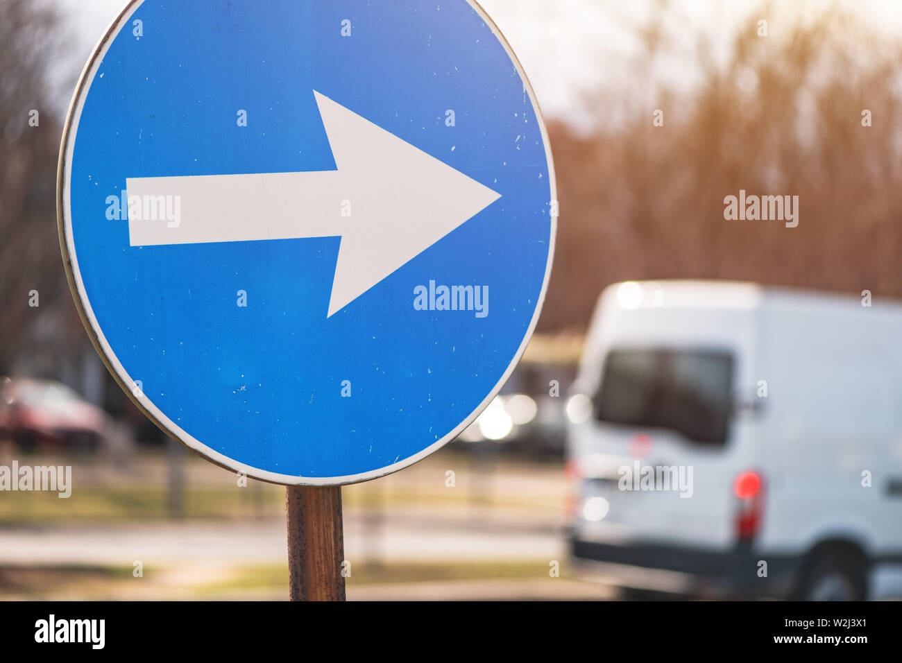 Proceed in direction arrow traffic sign on the street with defocussed ...