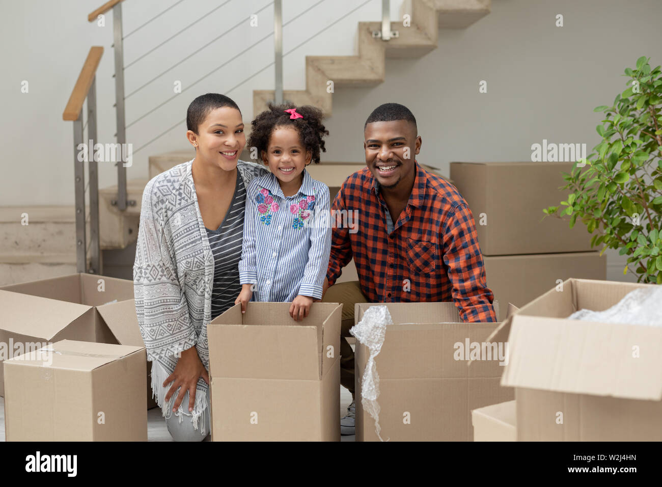 Family unpacking cardboard boxes in living room at home Stock Photo - Alamy