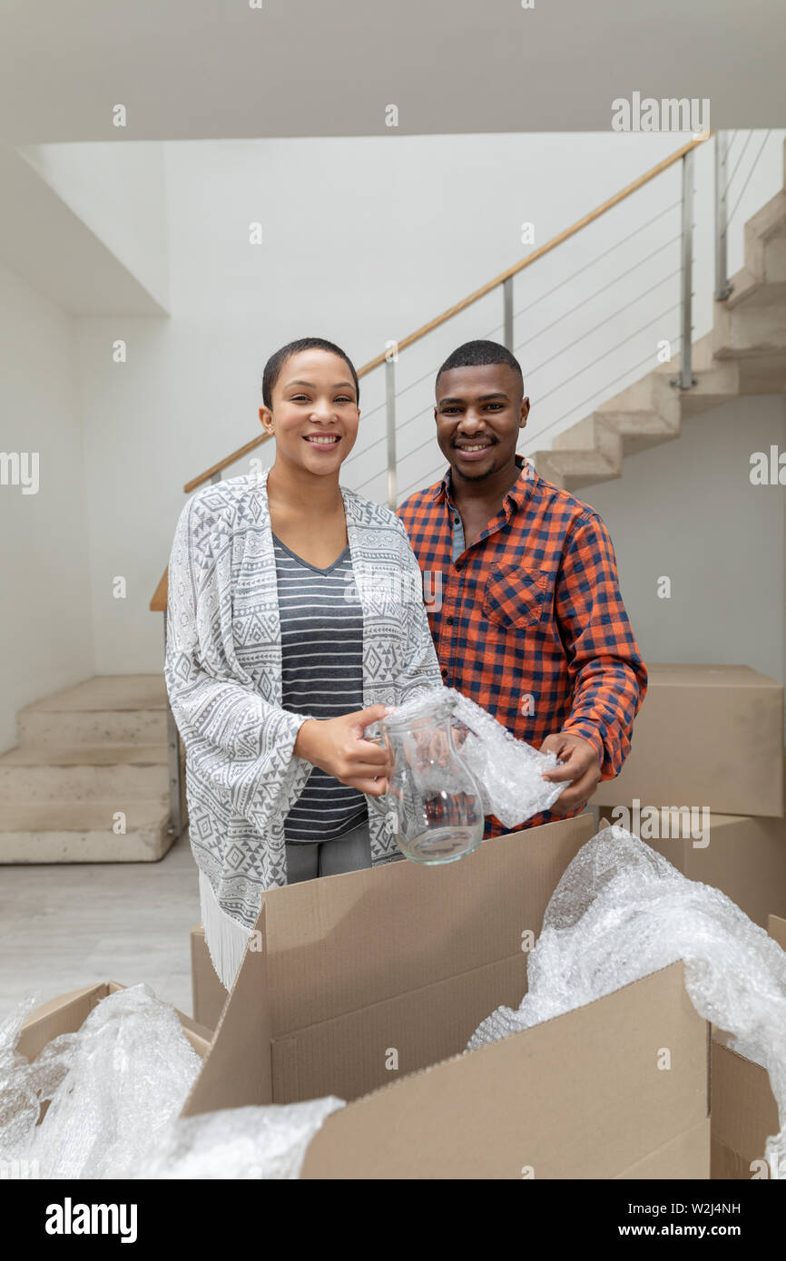 Couple unpacking cardboard boxes in living room at home Stock Photo - Alamy