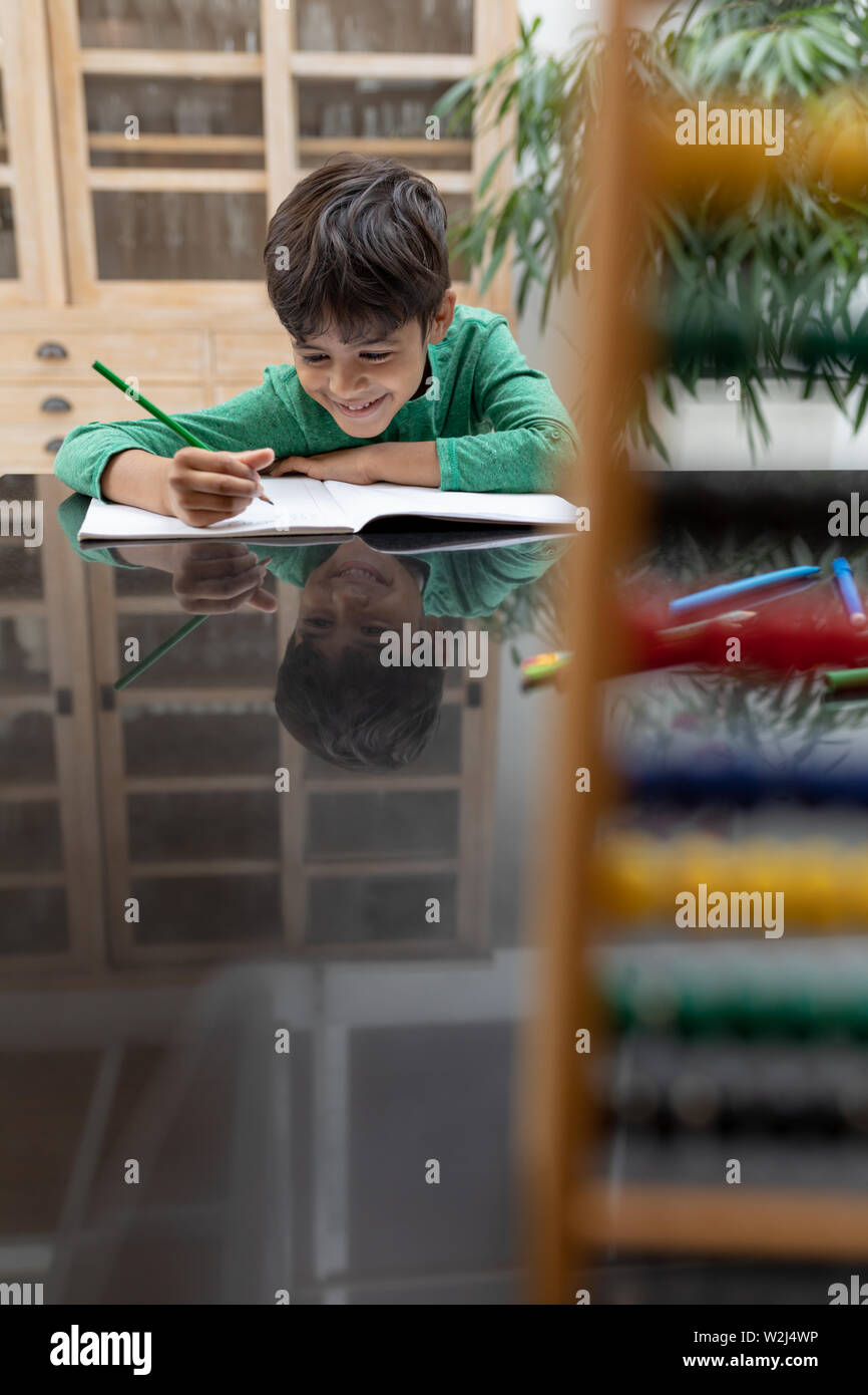 Boy doing his homework on a table Stock Photo - Alamy