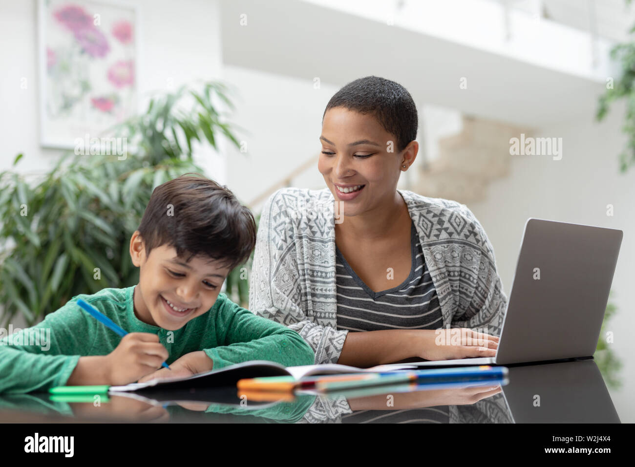 Mother helping his son with his homework on a table Stock Photo - Alamy