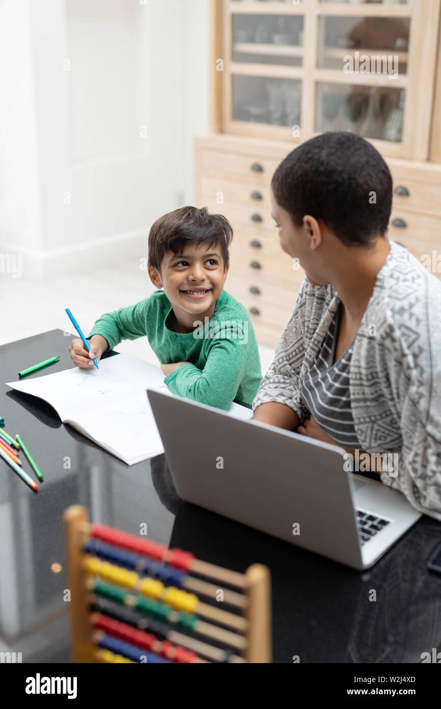 Mother helping his son with his homework on a table Stock Photo - Alamy