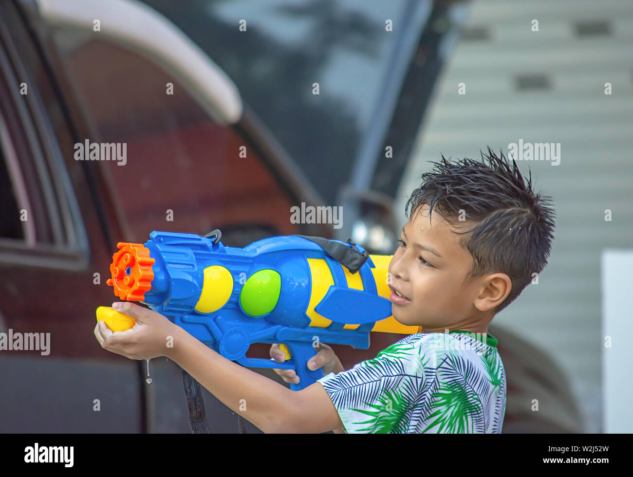 Asian boy holding a water gun play Songkran festival or Thai new year ...