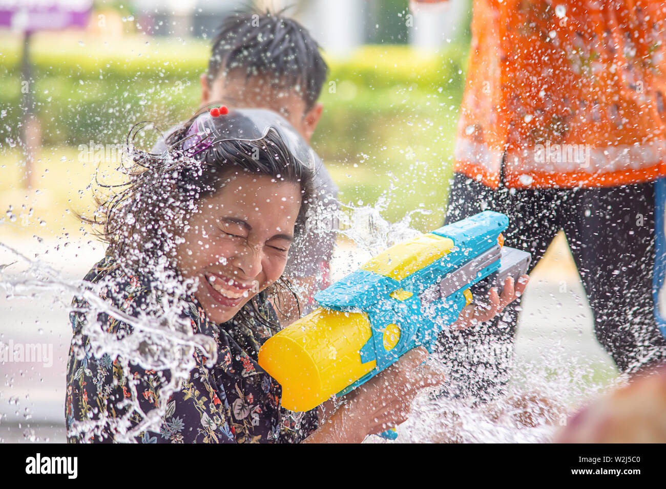 Asian woman holding a water gun play Songkran festival or Thai new year ...