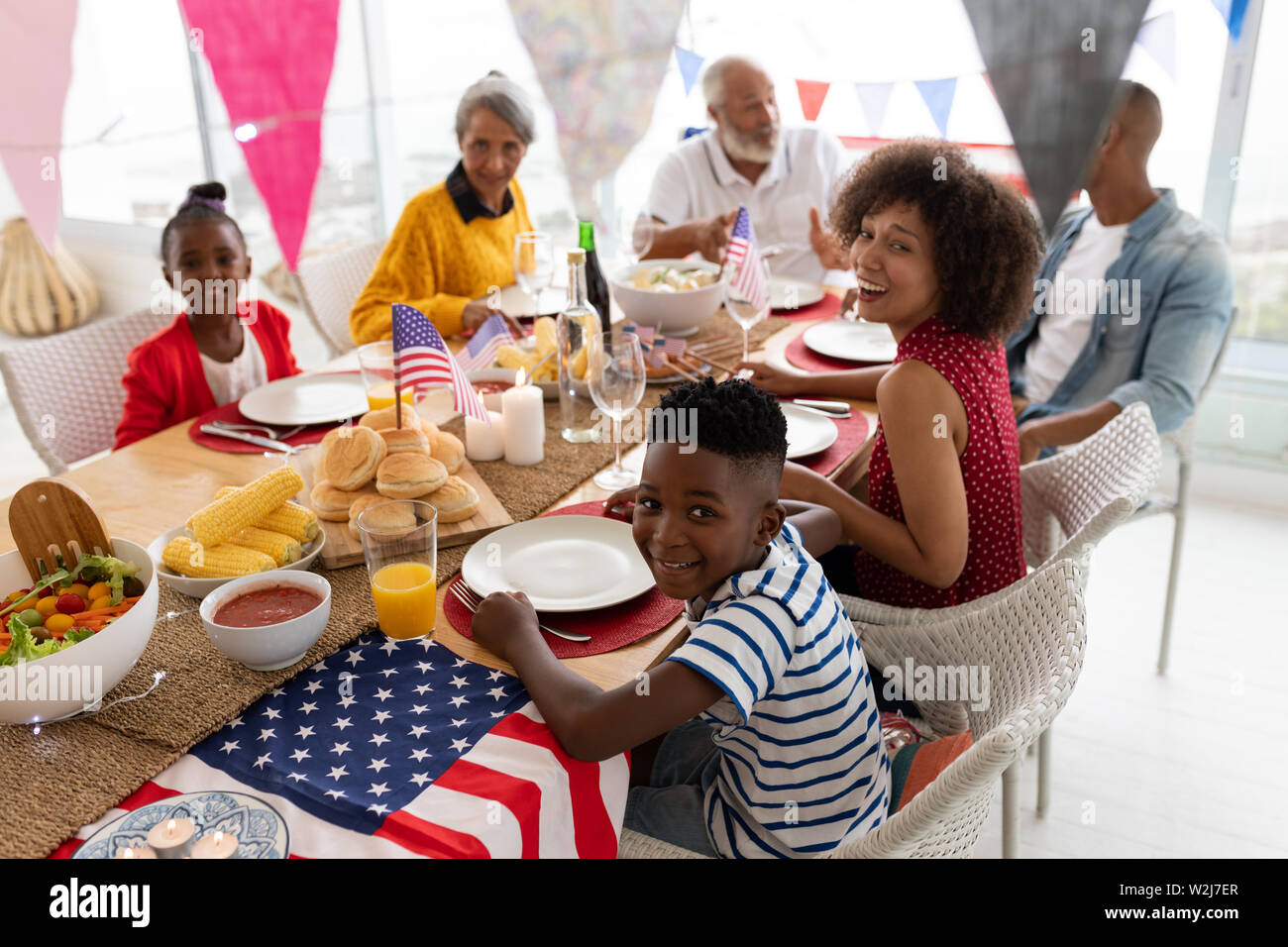 Multi-generation family sitting together for having meal on a dining ...