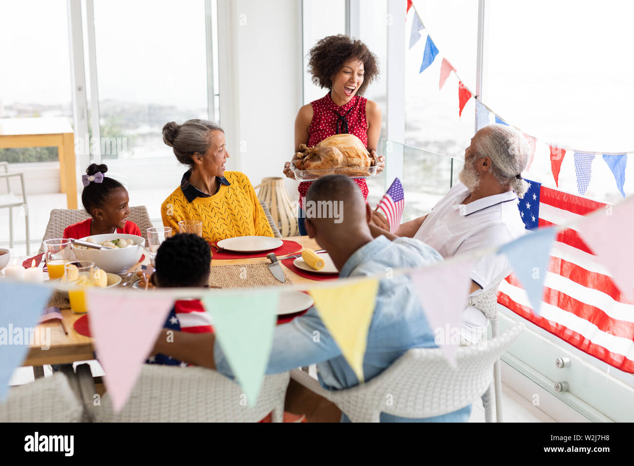 Multi-generation family sitting together for having meal on a dining ...