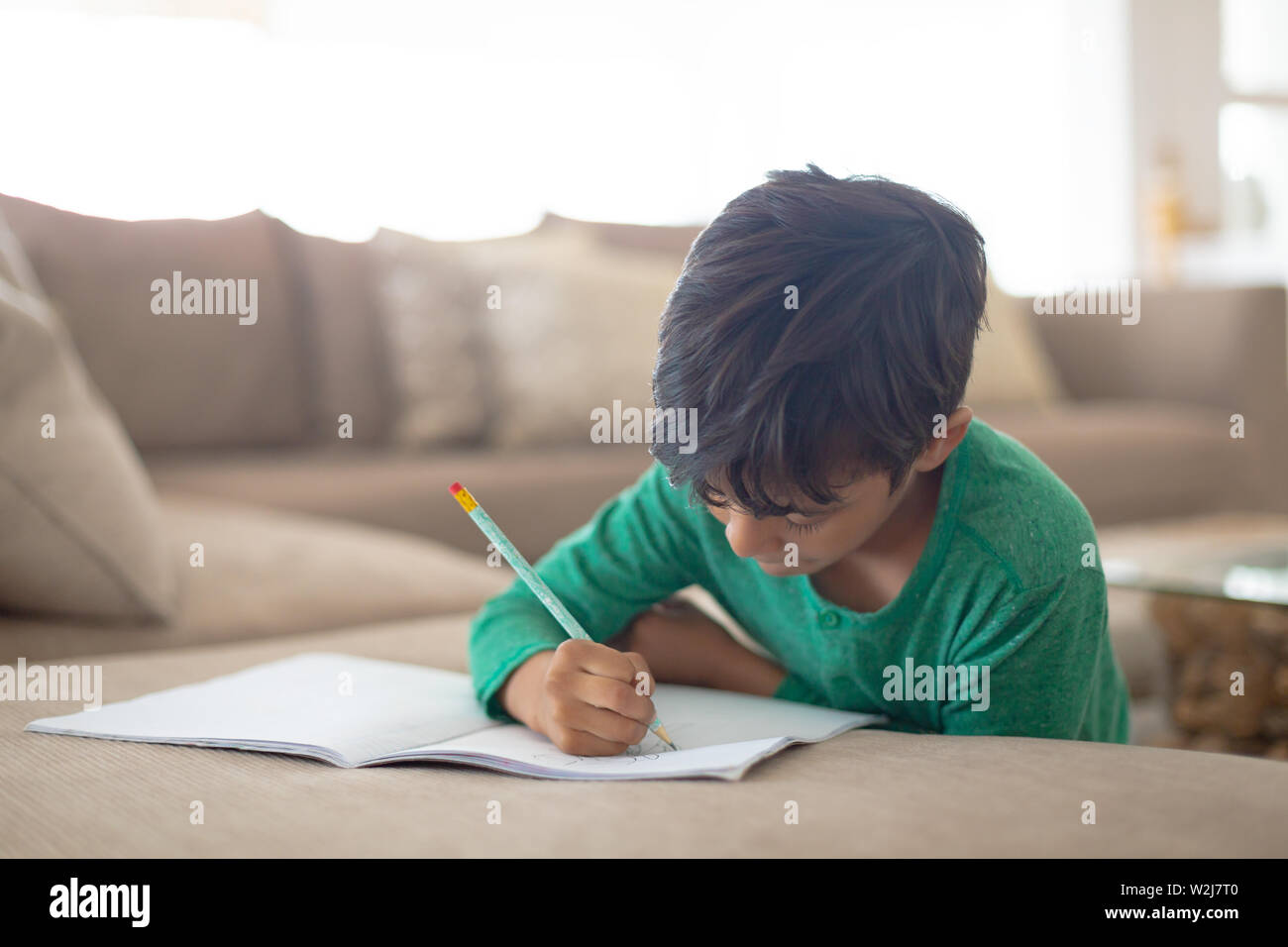 Boy drawing a sketch on book at home Stock Photo - Alamy