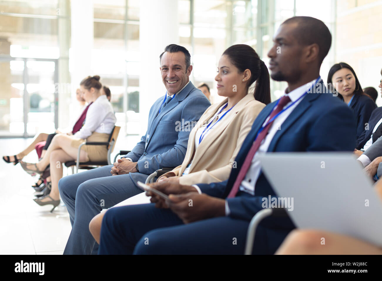 Group of diverse executives sat in conference room, smiling to camera ...