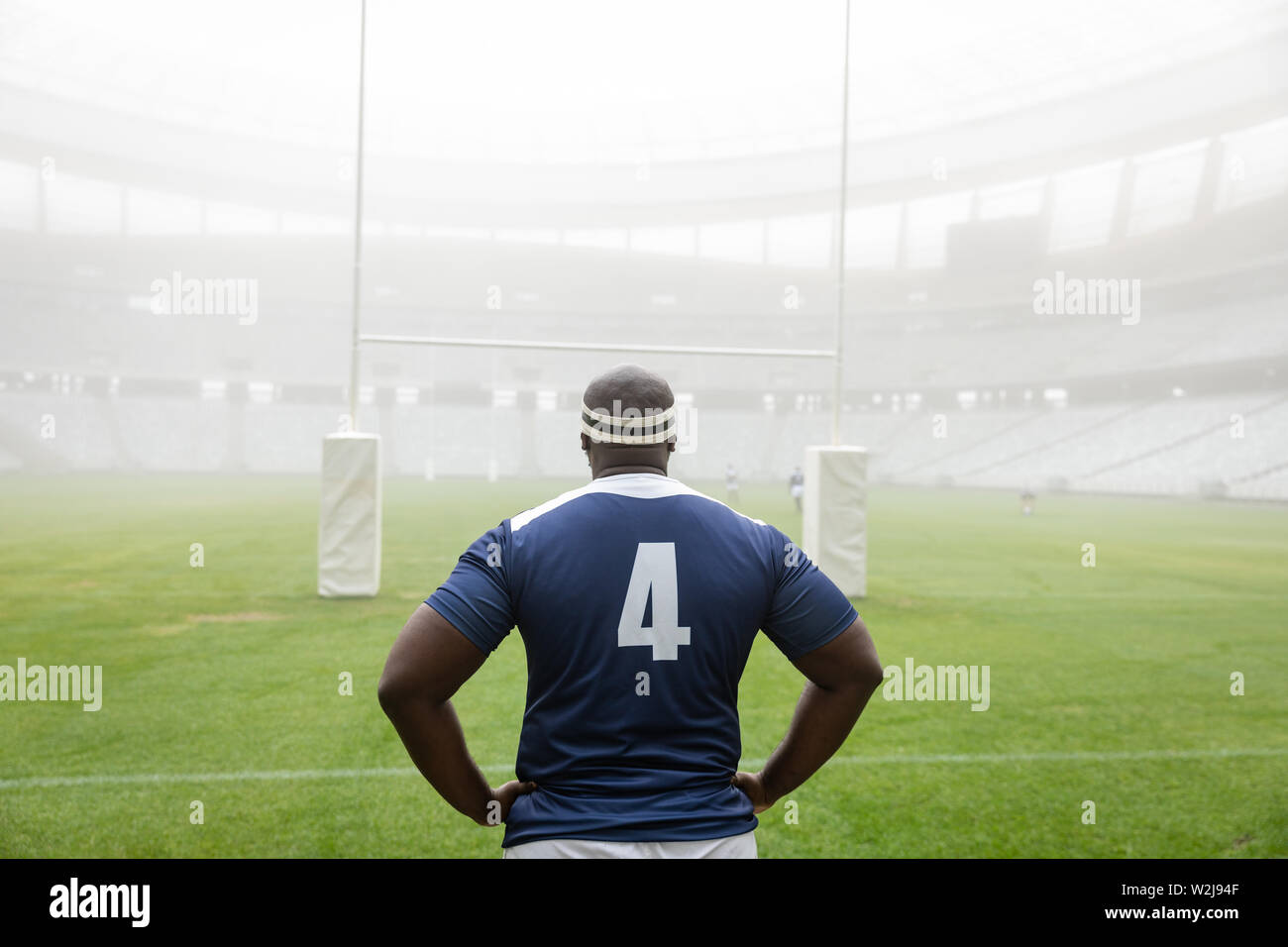 African american male rugby player standing with hands on hip in ...