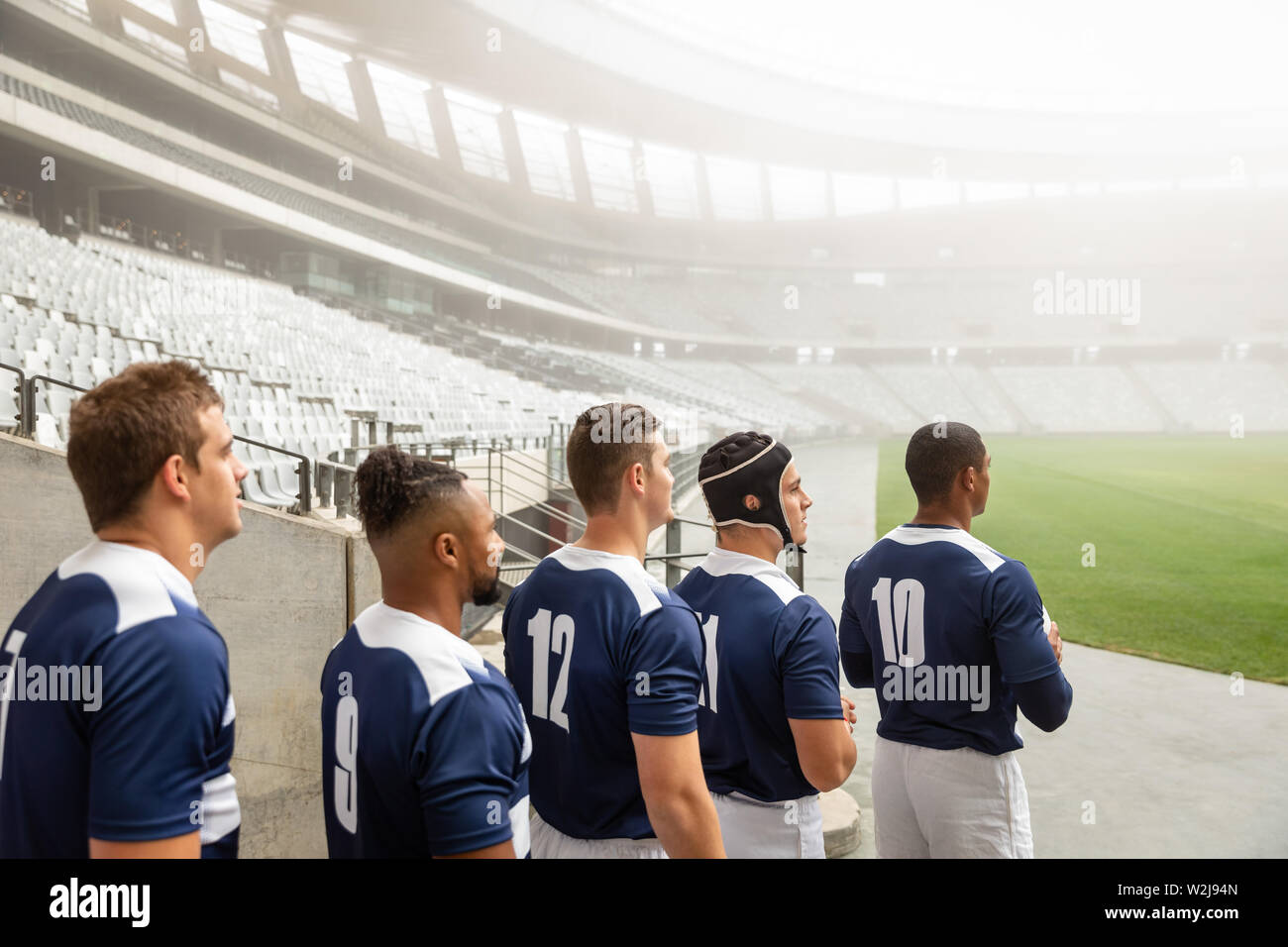 Group of diverse male rugby players standing at the entrance of stadium ...