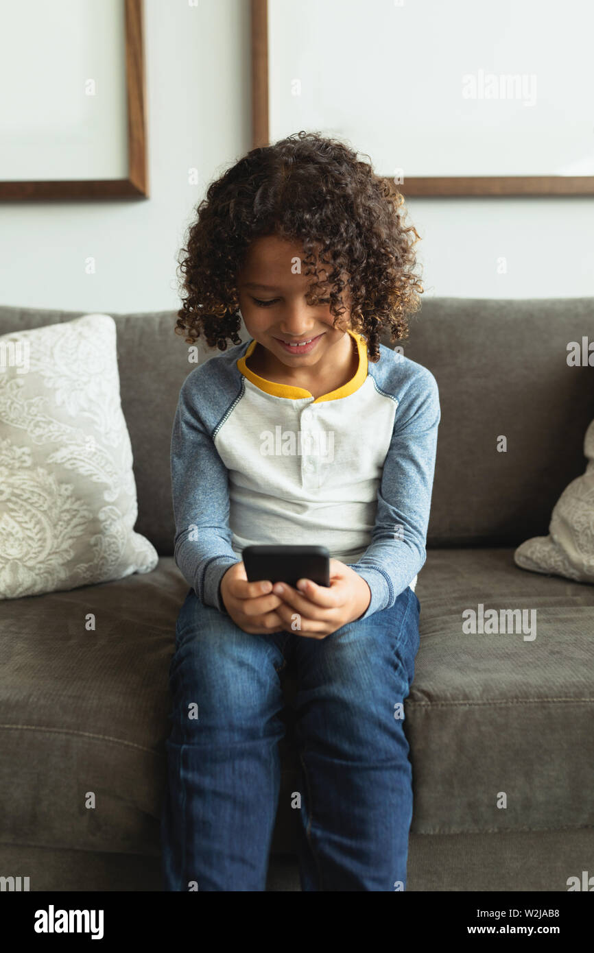 Boy using mobile phone in the lobby at hospital Stock Photo - Alamy