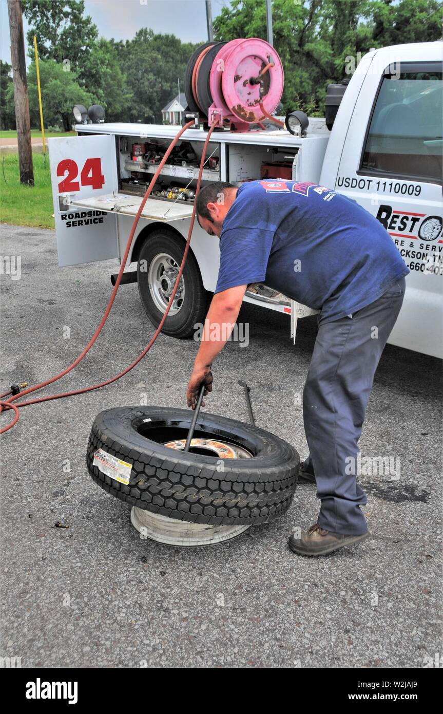 Repairman fixing exchanging a flat tire on rental Uhaul truck on the ...