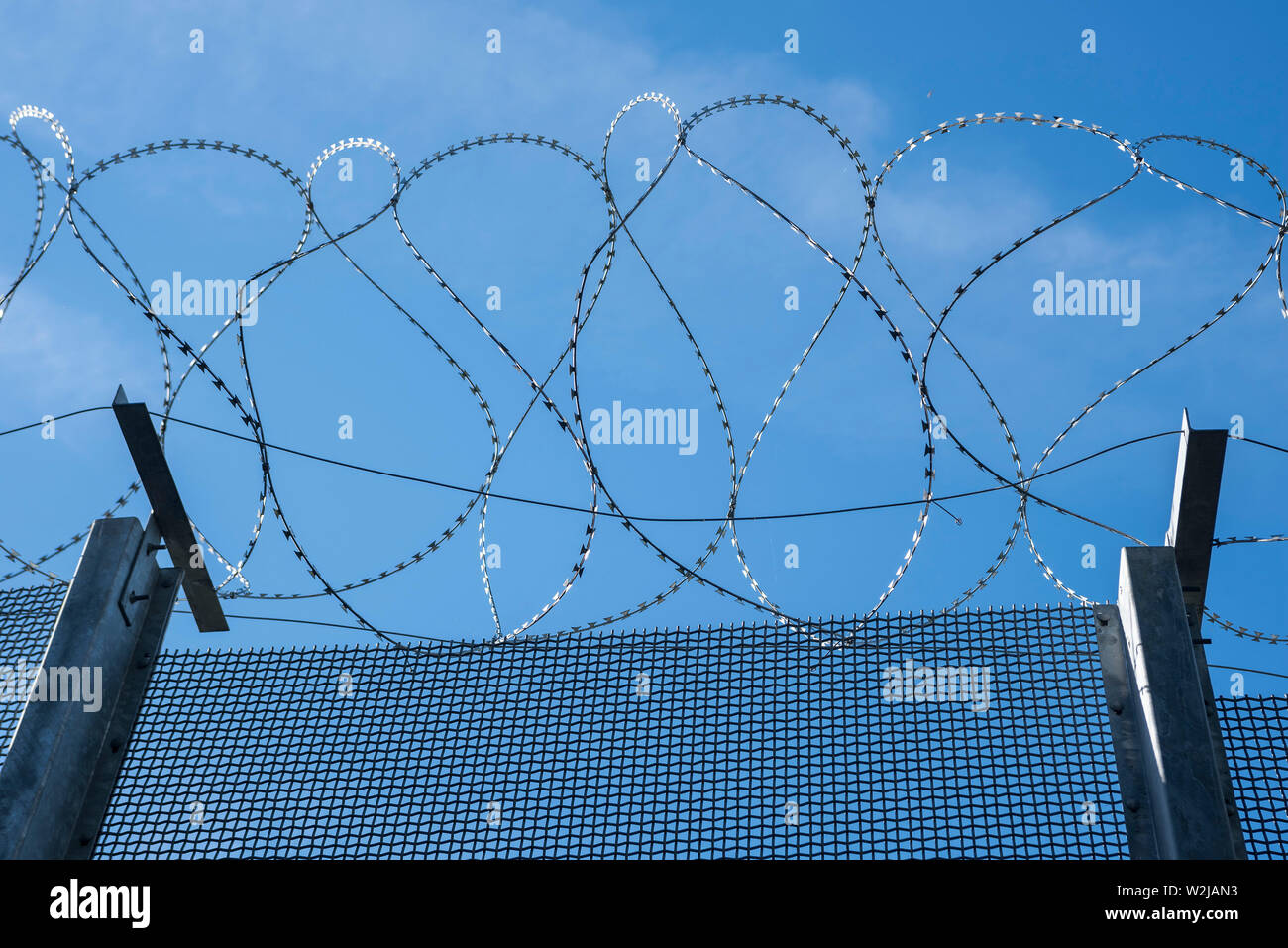 Security fence topped with razor wire Stock Photo - Alamy