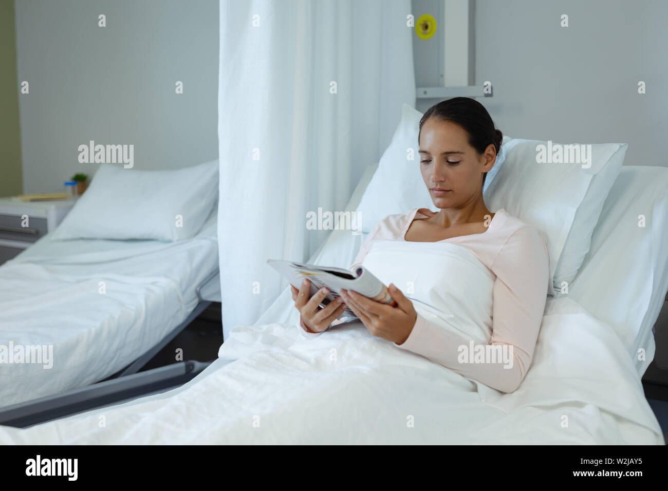 Female patient reading book in the ward at hospital Stock Photo - Alamy