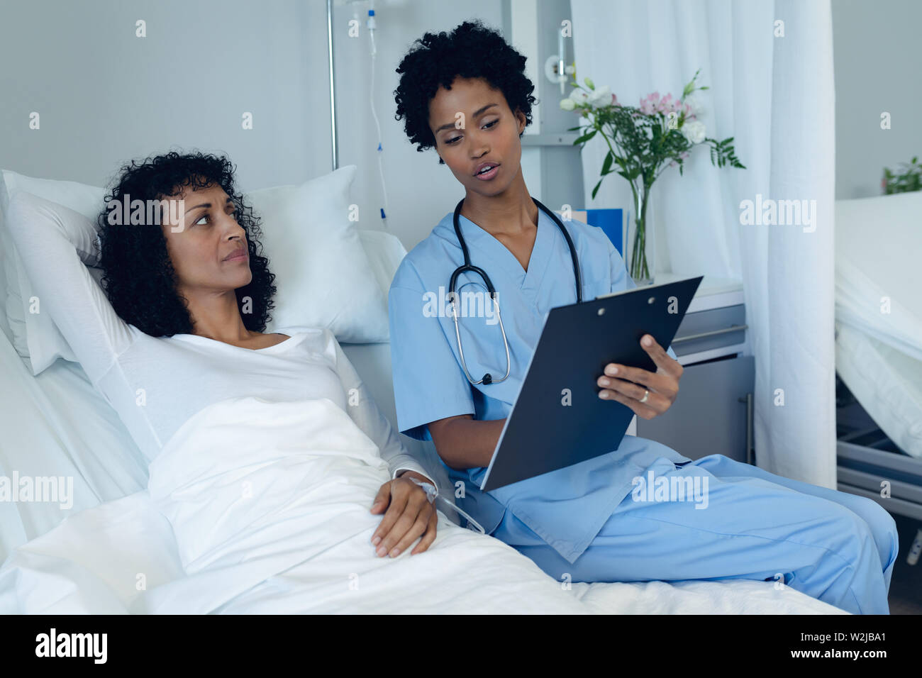 Female doctor interacting with female patient in the ward Stock Photo ...