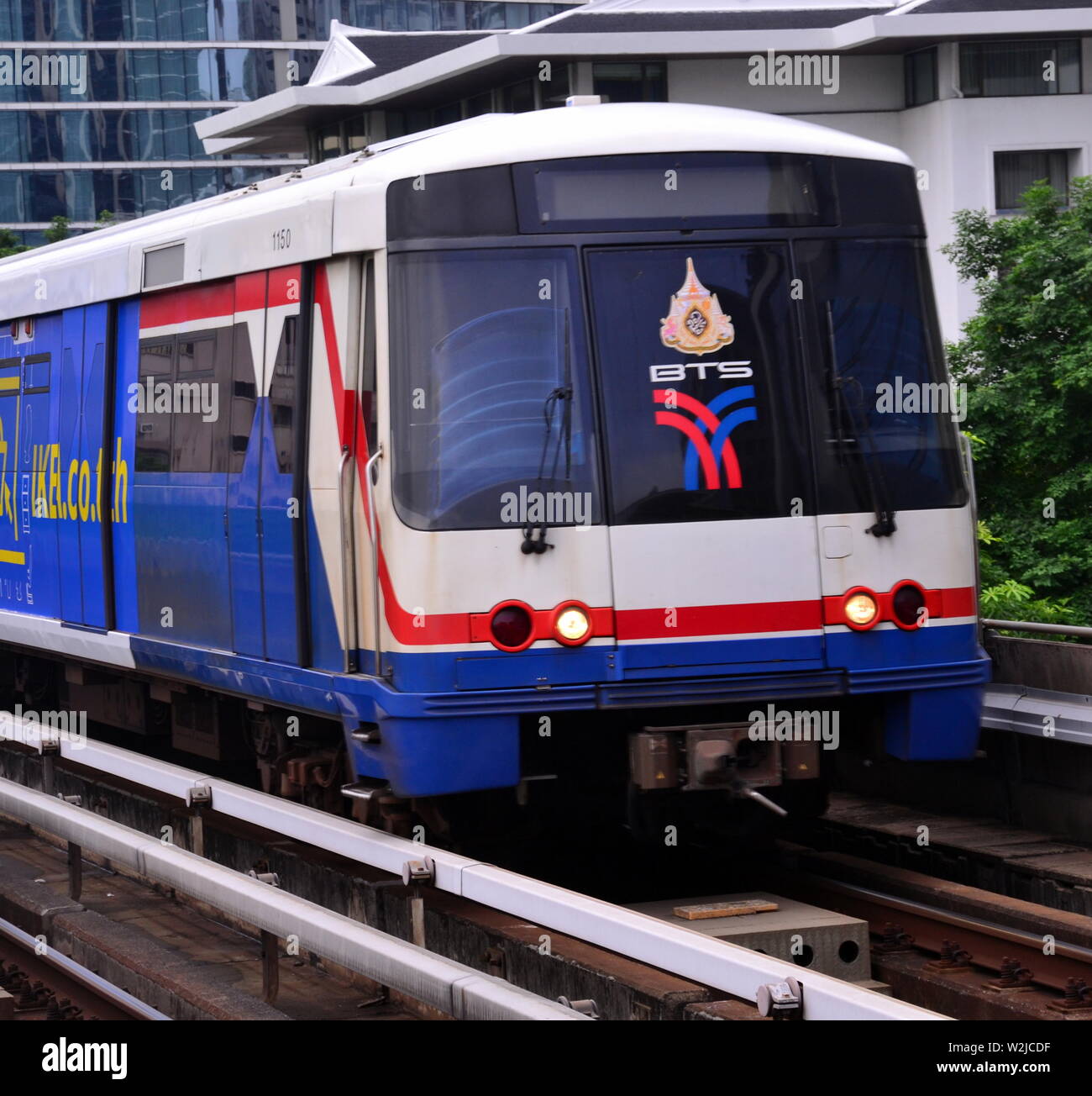 A skytrain approaches Ratchadamri Station on the Silom line, in central ...