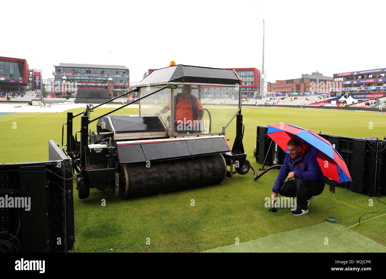 Ground staff work on the rain soaked ground during the ICC World Cup ...
