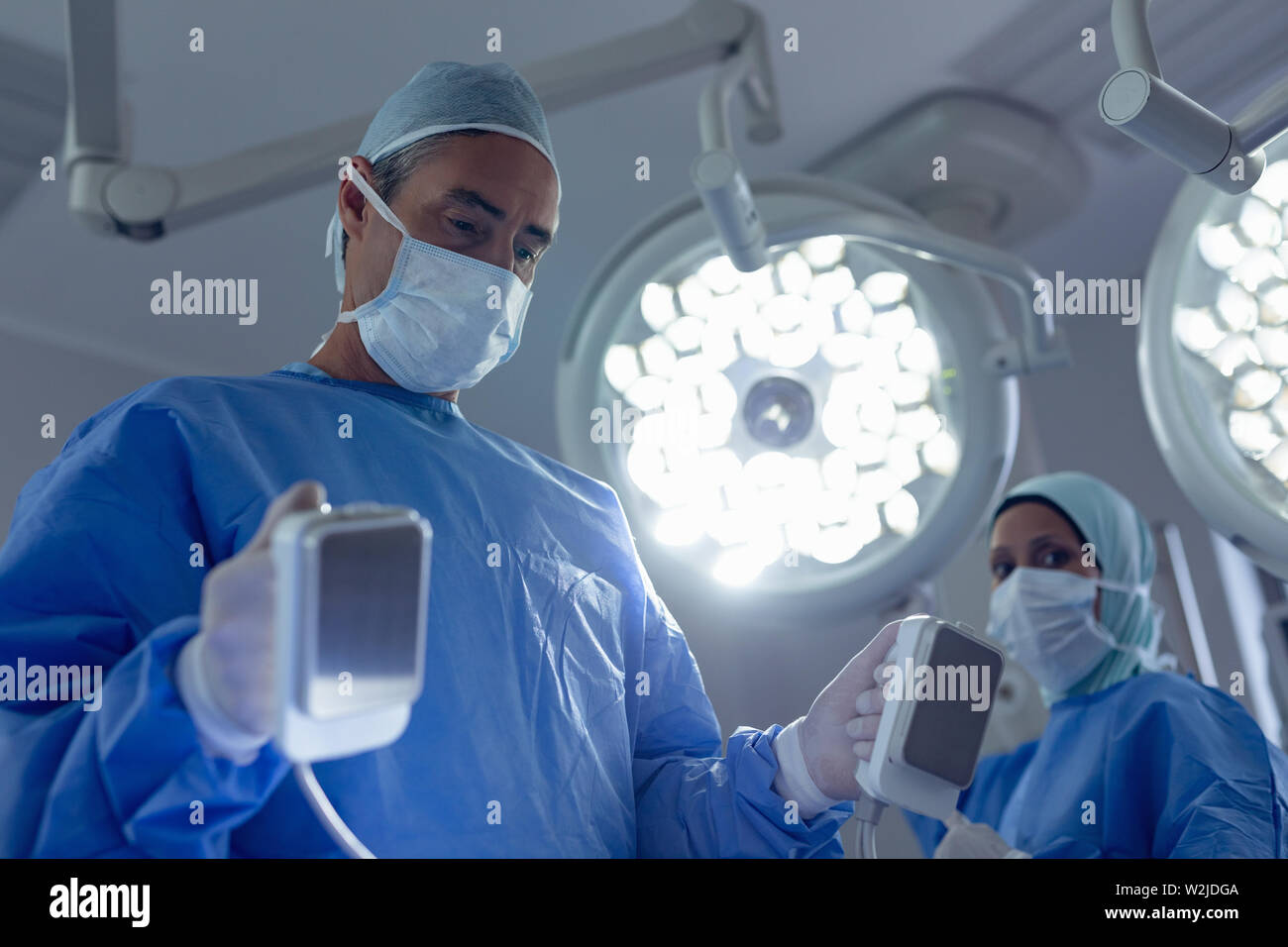 Male surgeon holding defibrillator in operation room at hospital Stock ...