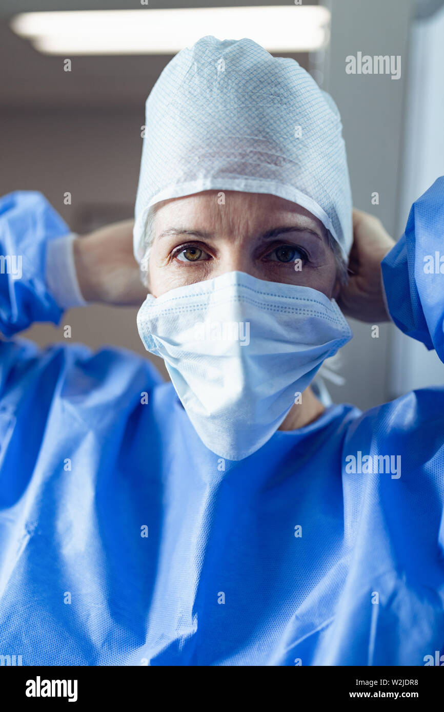 Female surgeon wearing surgical mask in operation theater at hospital ...