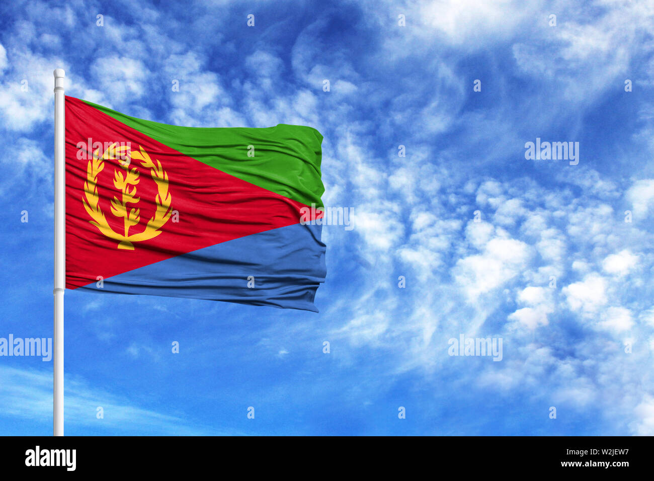 National flag of Eritrea on a flagpole in front of blue sky Stock Photo ...