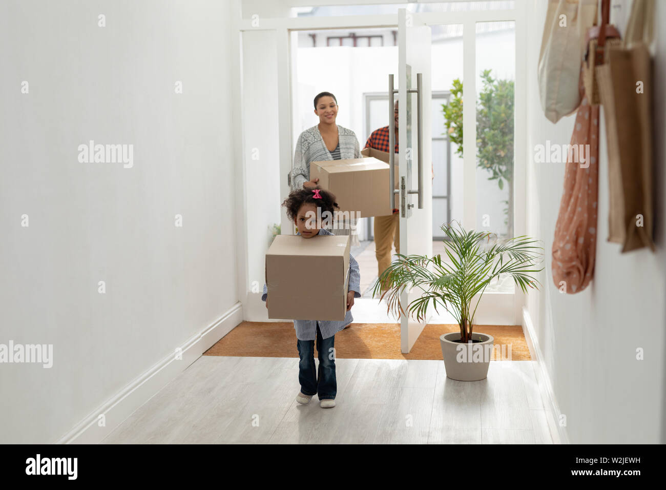 Family with cardboard boxes entering their new home Stock Photo - Alamy