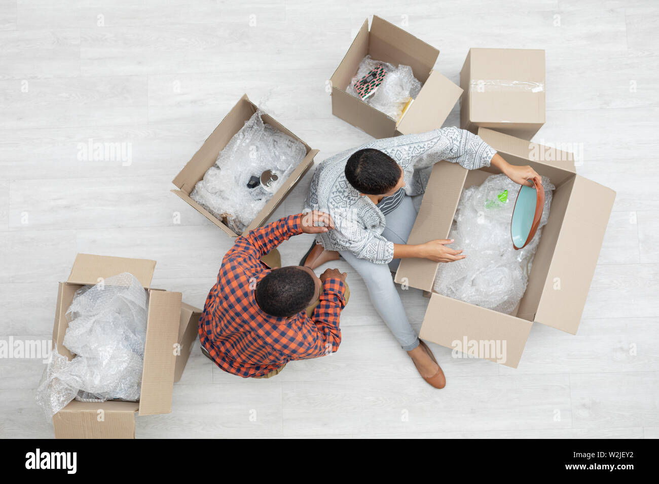 Couple unpacking cardboard boxes in living room Stock Photo - Alamy